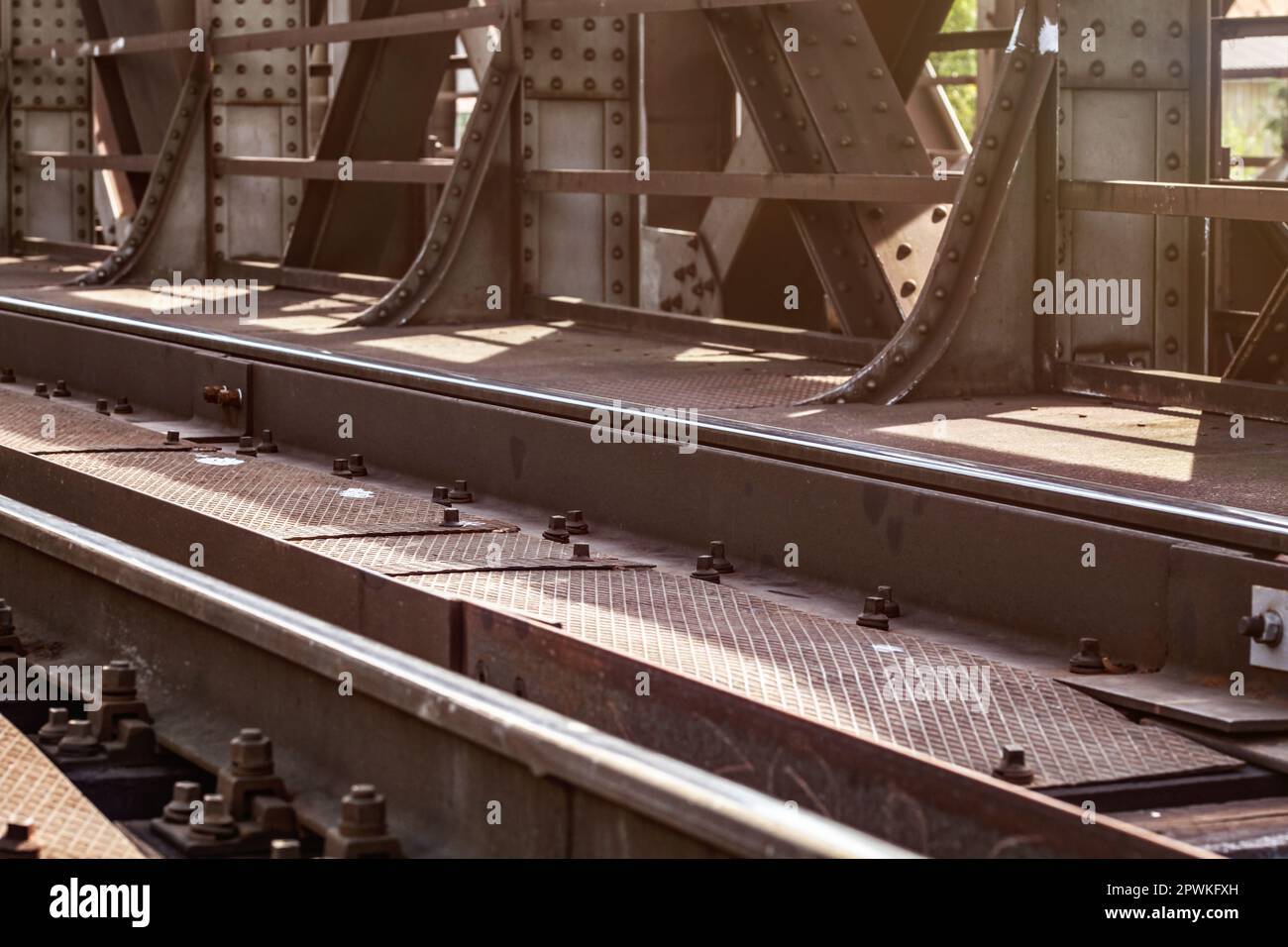 Rail bridge, detail on tracks, steel plates, large nuts and bolts lit ...