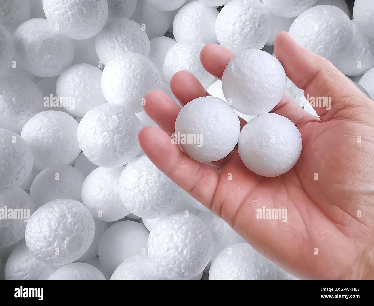 Hand holding white polystyrene foam beads ball drop from Styrofoam ...