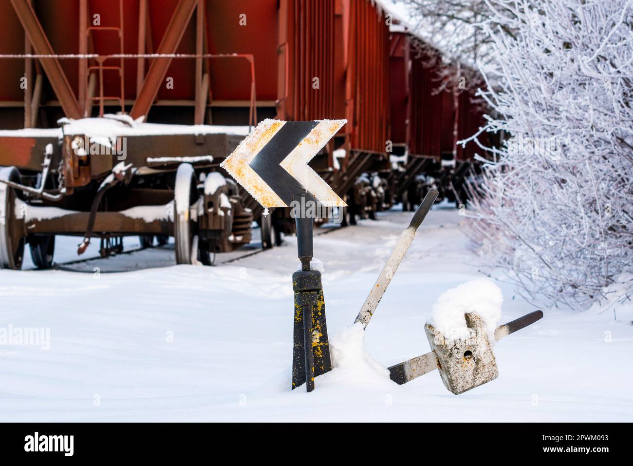 Railroad switch with train in the winter. Old Railway arrow in a winter ...