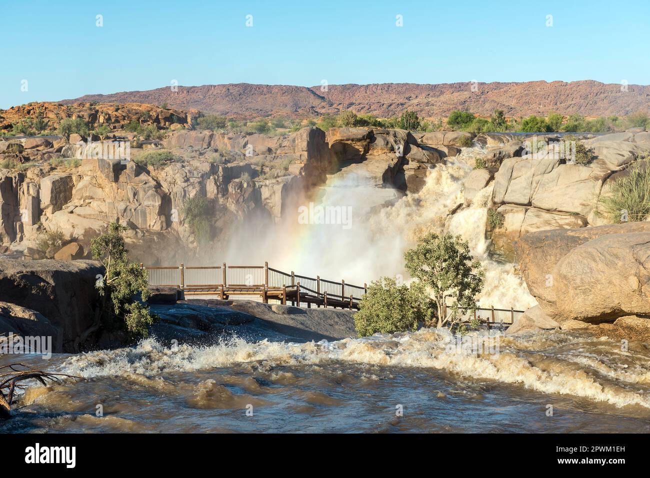 A rainbow is visible over a boardwalk at the Augrabies waterfalls in ...