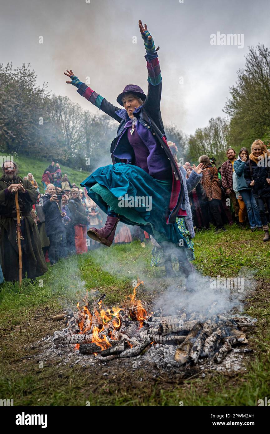 People jump the Beltane bonfire at Chalice Well, Glastonbury, Somerset ...