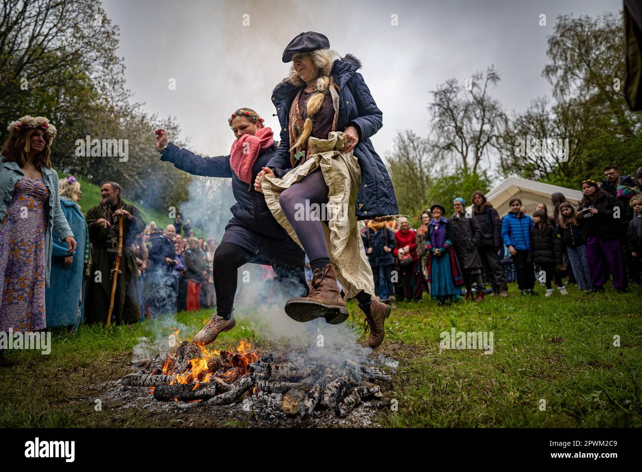 People jump the Beltane bonfire at Chalice Well, Glastonbury, Somerset ...