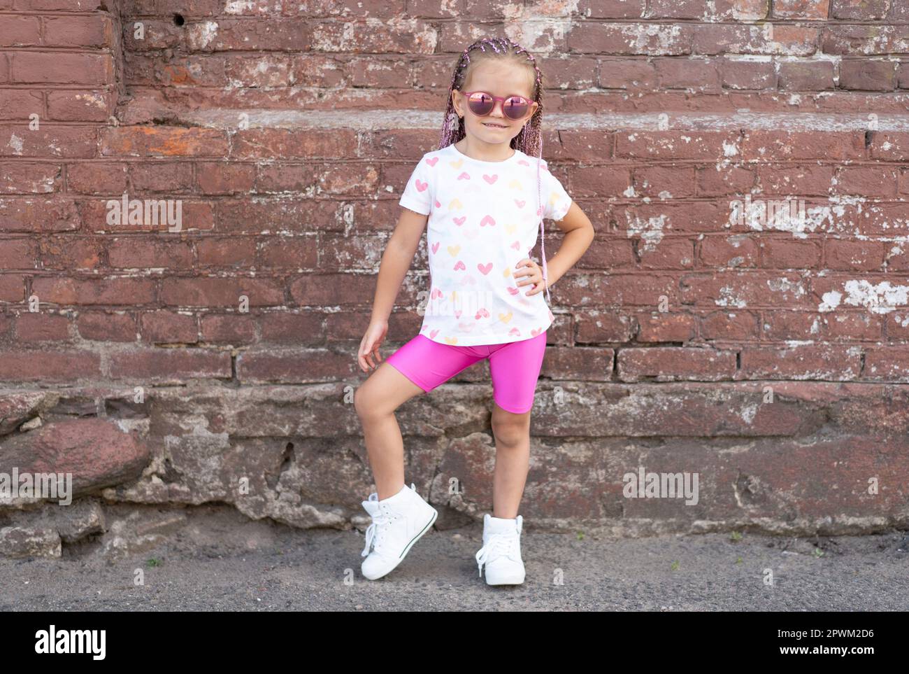 little girl wearing bright clothes and sunglasses against the colorful ...