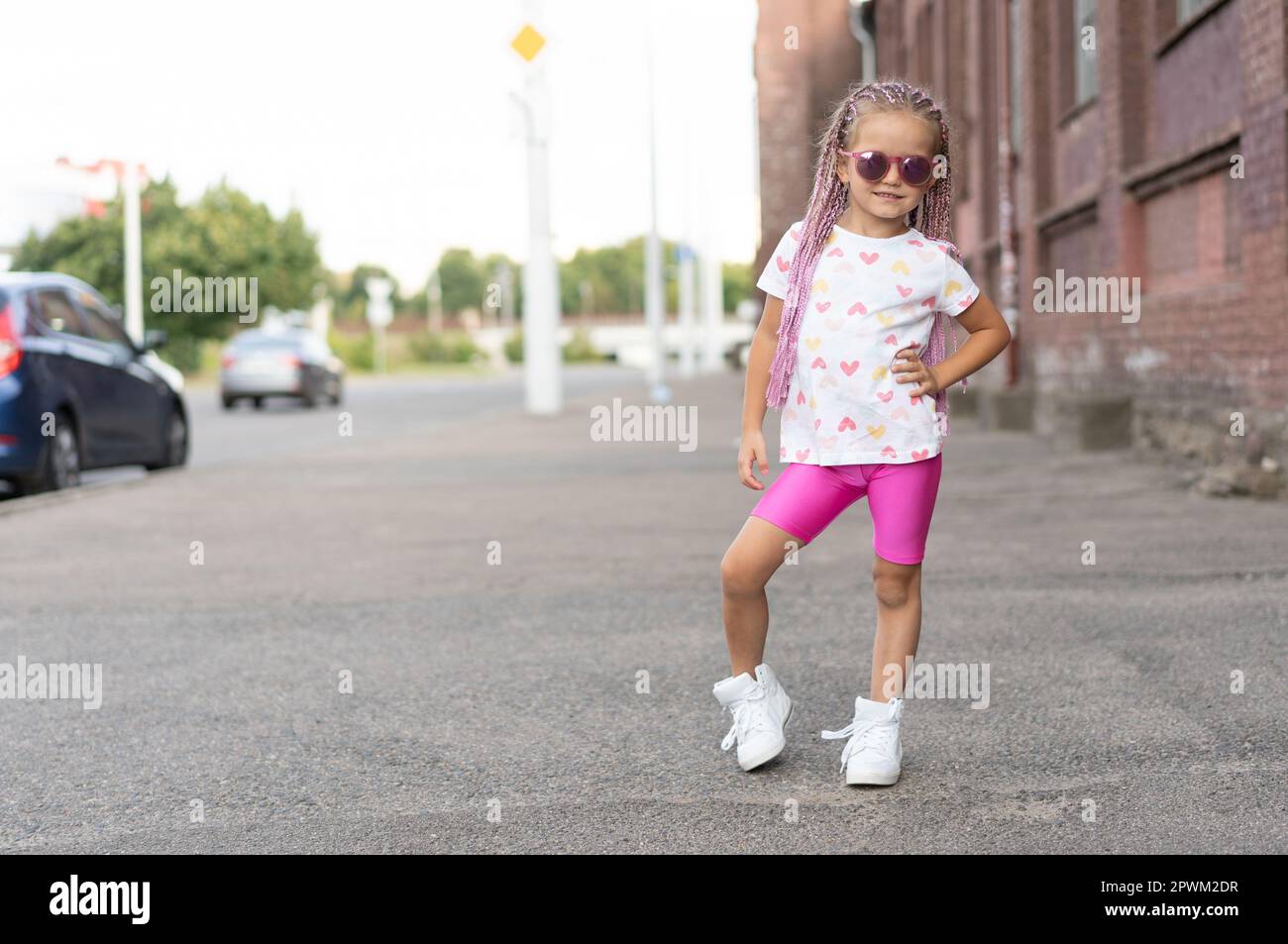 little girl wearing bright clothes and sunglasses against the colorful ...