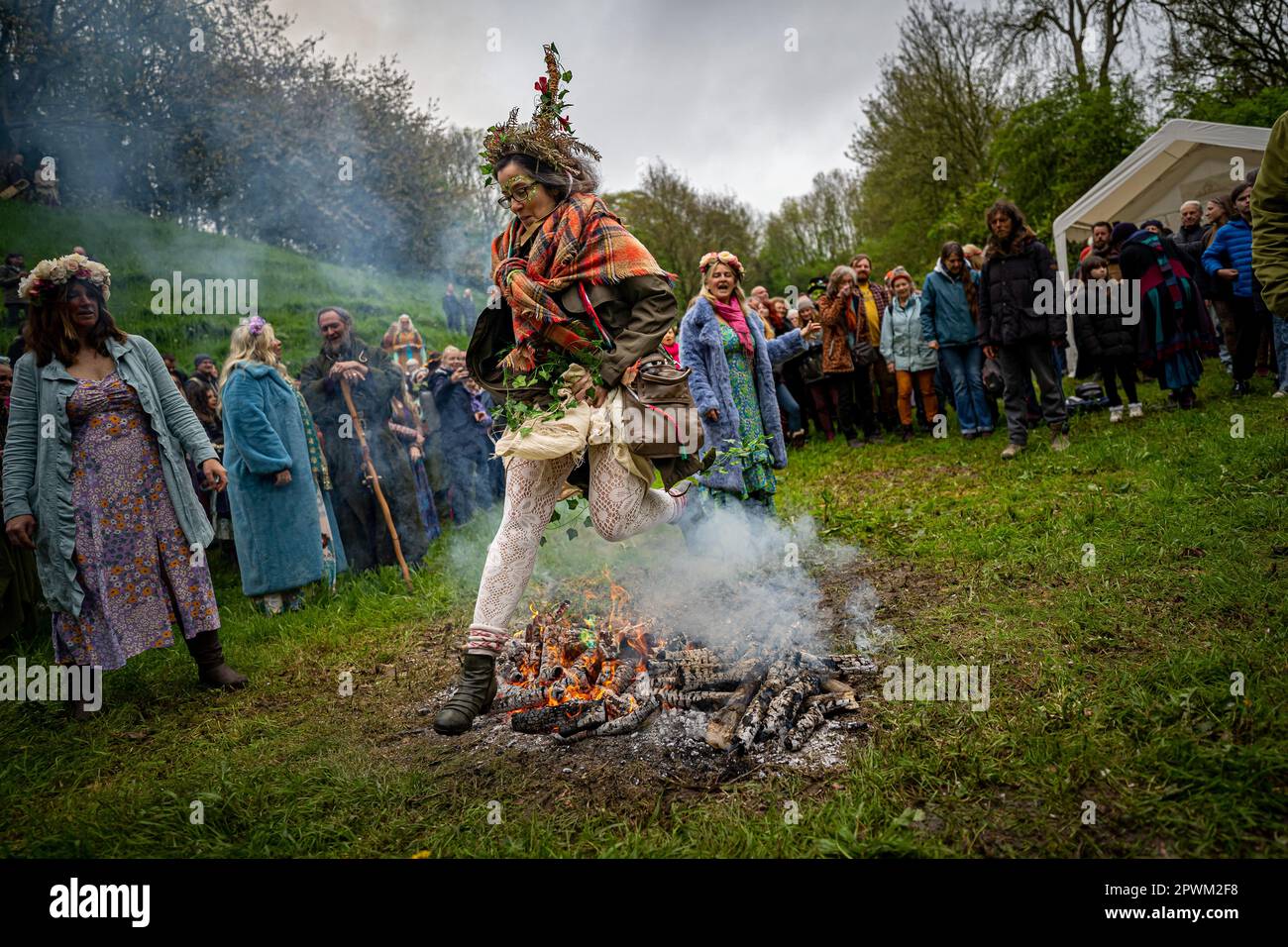 People jump the Beltane bonfire at Chalice Well, Glastonbury, Somerset ...