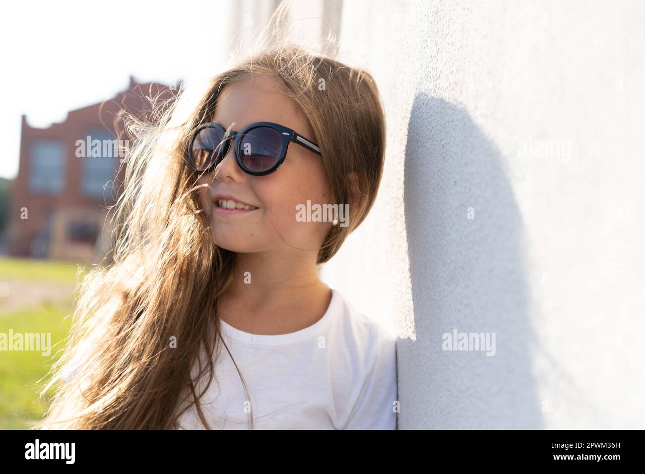 stylish girl child wearing bright clothes and sunglasses against the ...