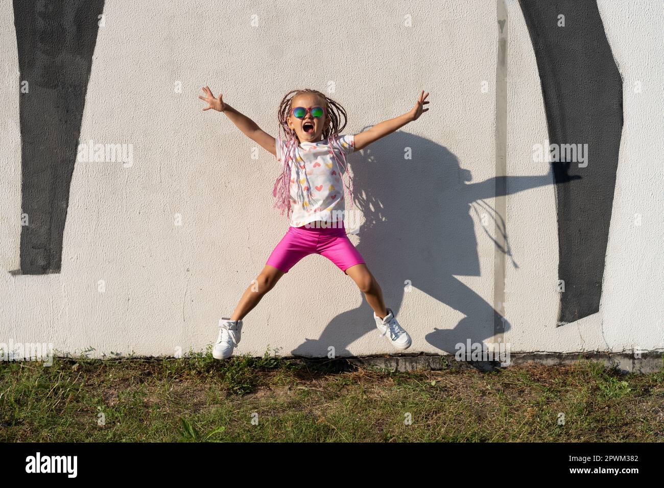 stylish little girl jumping outside Stock Photo - Alamy
