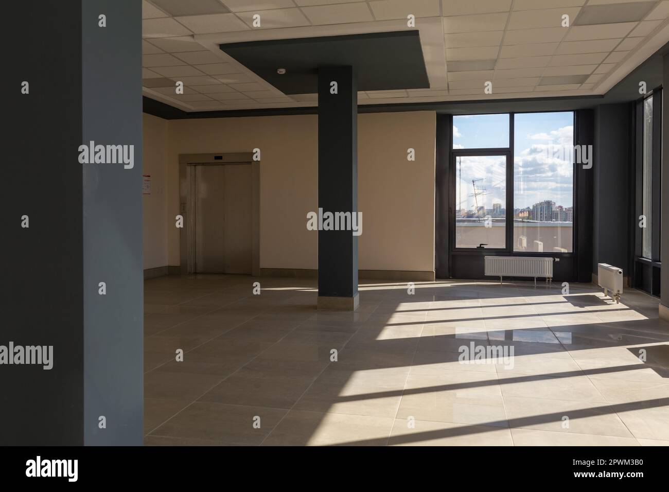 A large, spacious, empty room with huge windows and floor-mounted ...