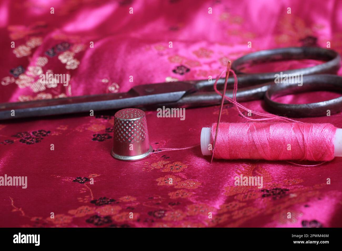 Spool of Pink Thread and Thimble on Vintage Pink Satin Stock Photo - Alamy