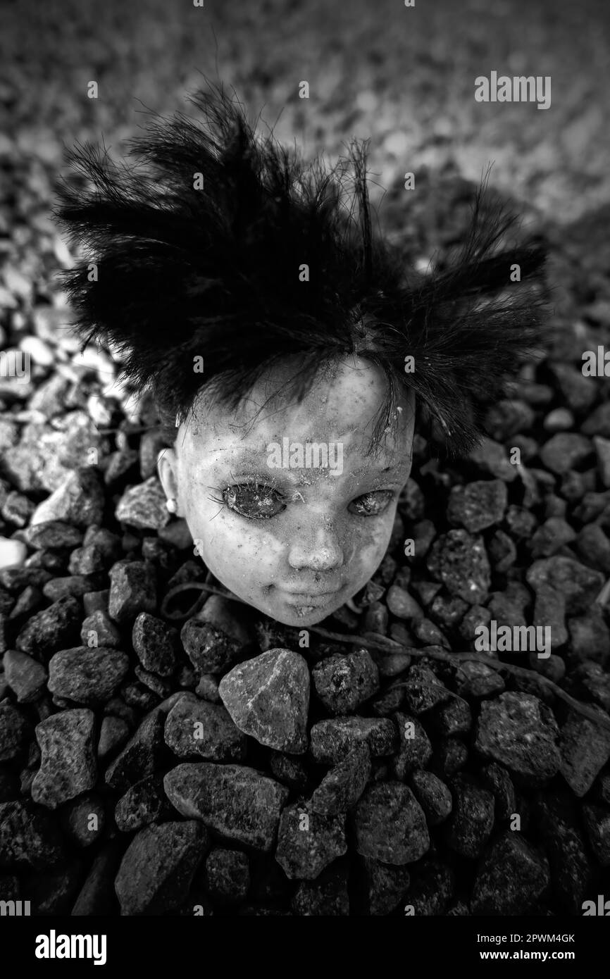 Detail of old creepy doll thrown in the trash Stock Photo - Alamy