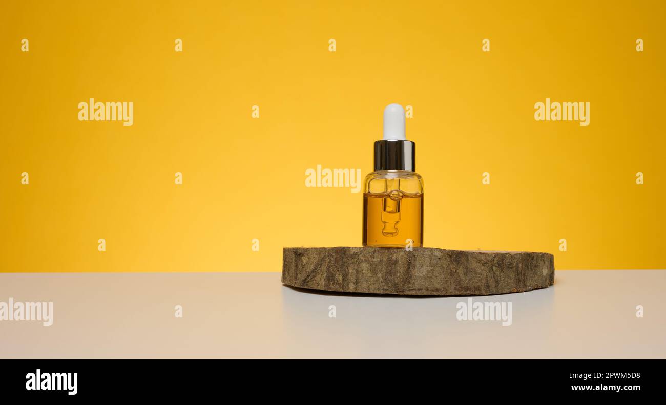 Glass transparent bottle with pipette and yellow oil. Containers for ...