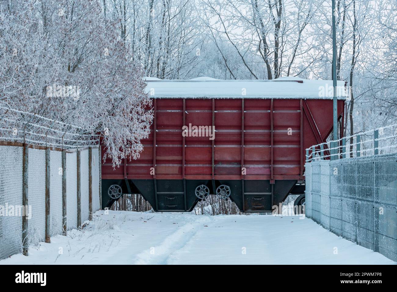 Carriages of a cargo train rides through a snow covered railway line ...