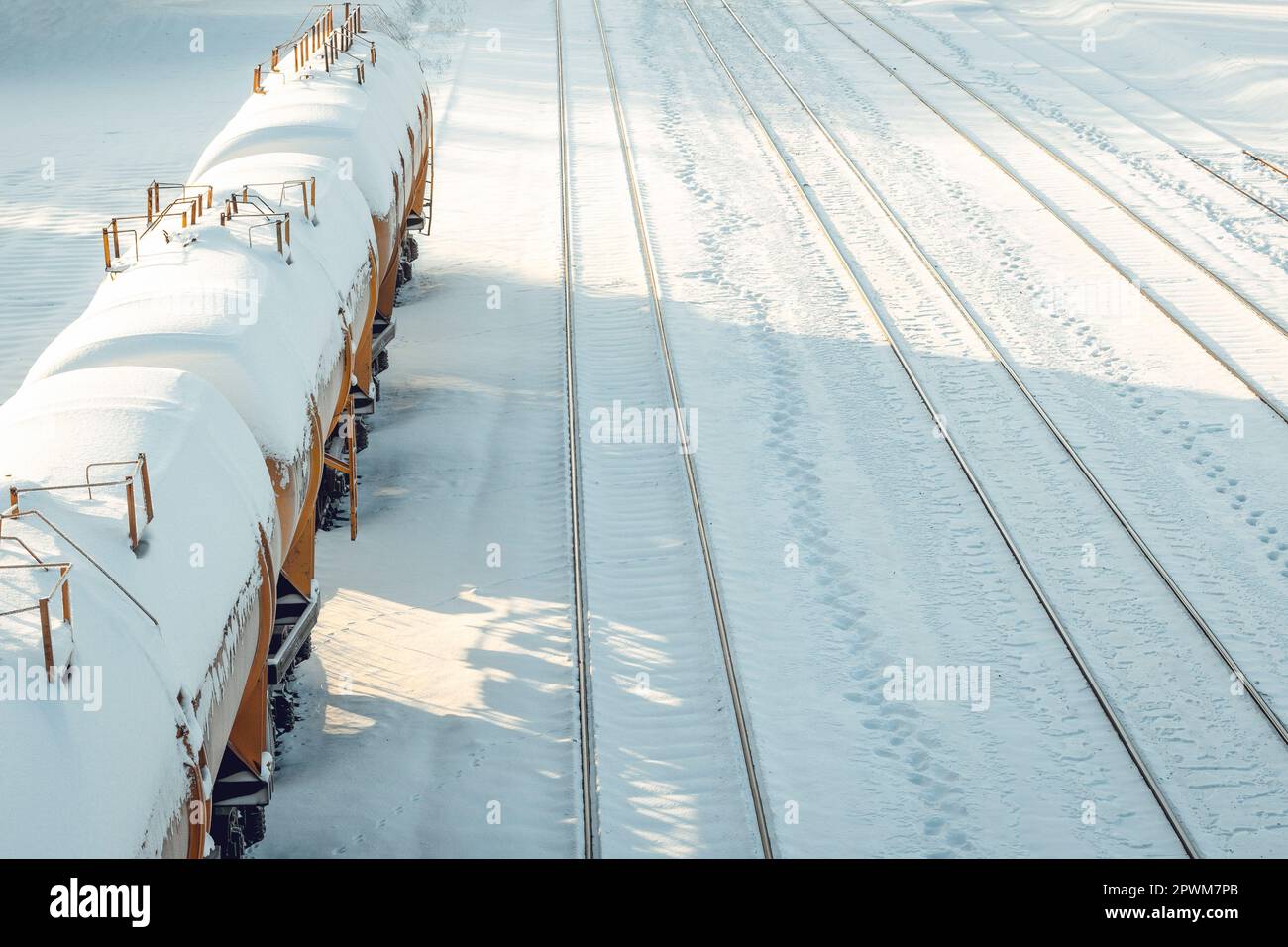 Snow covered tank-wagons with crude oil standing on the railway. View ...