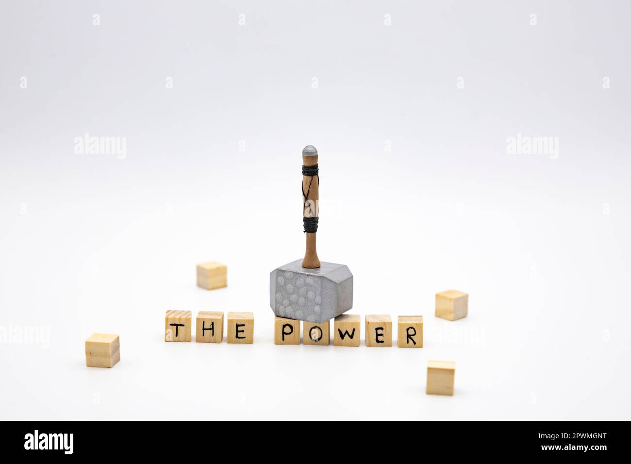 The hammer is standing on the wooden cubes with the words THE POWER ...