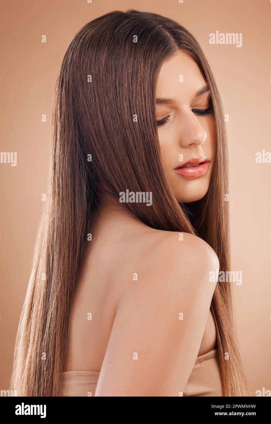 Woman, beauty and hair care in studio for shine, glow and long straight texture on brown ...