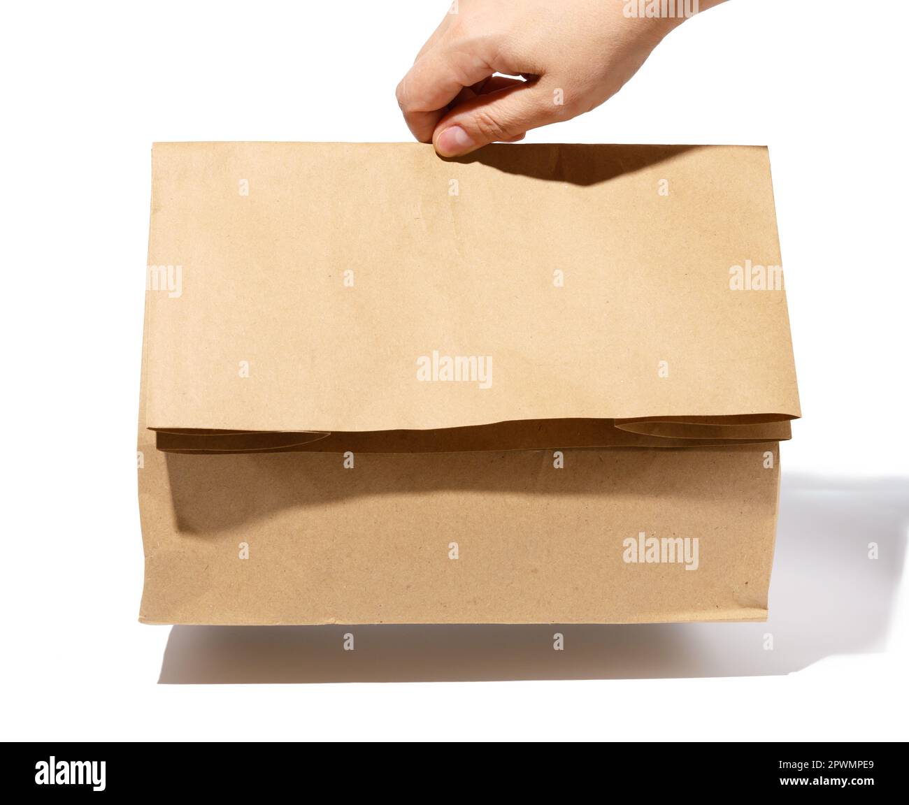 Female hand holding a full brown paper bag on a white background Stock ...