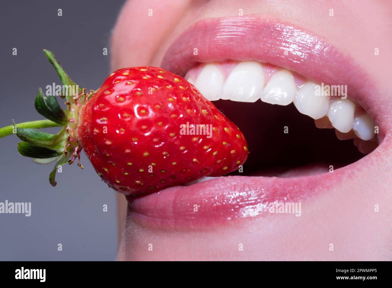 Strawberry in lips. Red strawberry in woman mouths close up. Closeup of ...