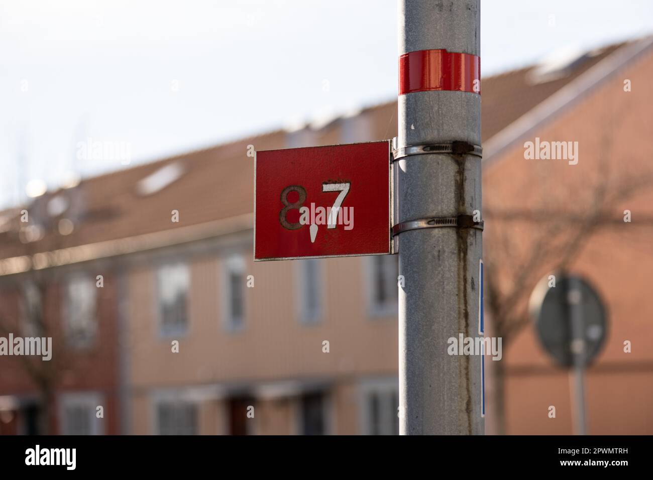 Small red sign telling the direction and distance to teh nearest water ...