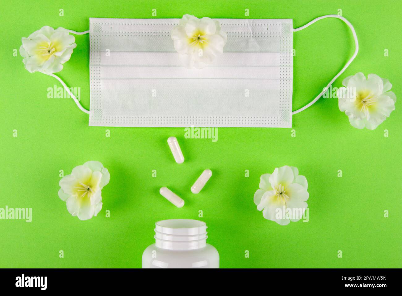 Striking juxtaposition of face mask and handful of capsule pills ...