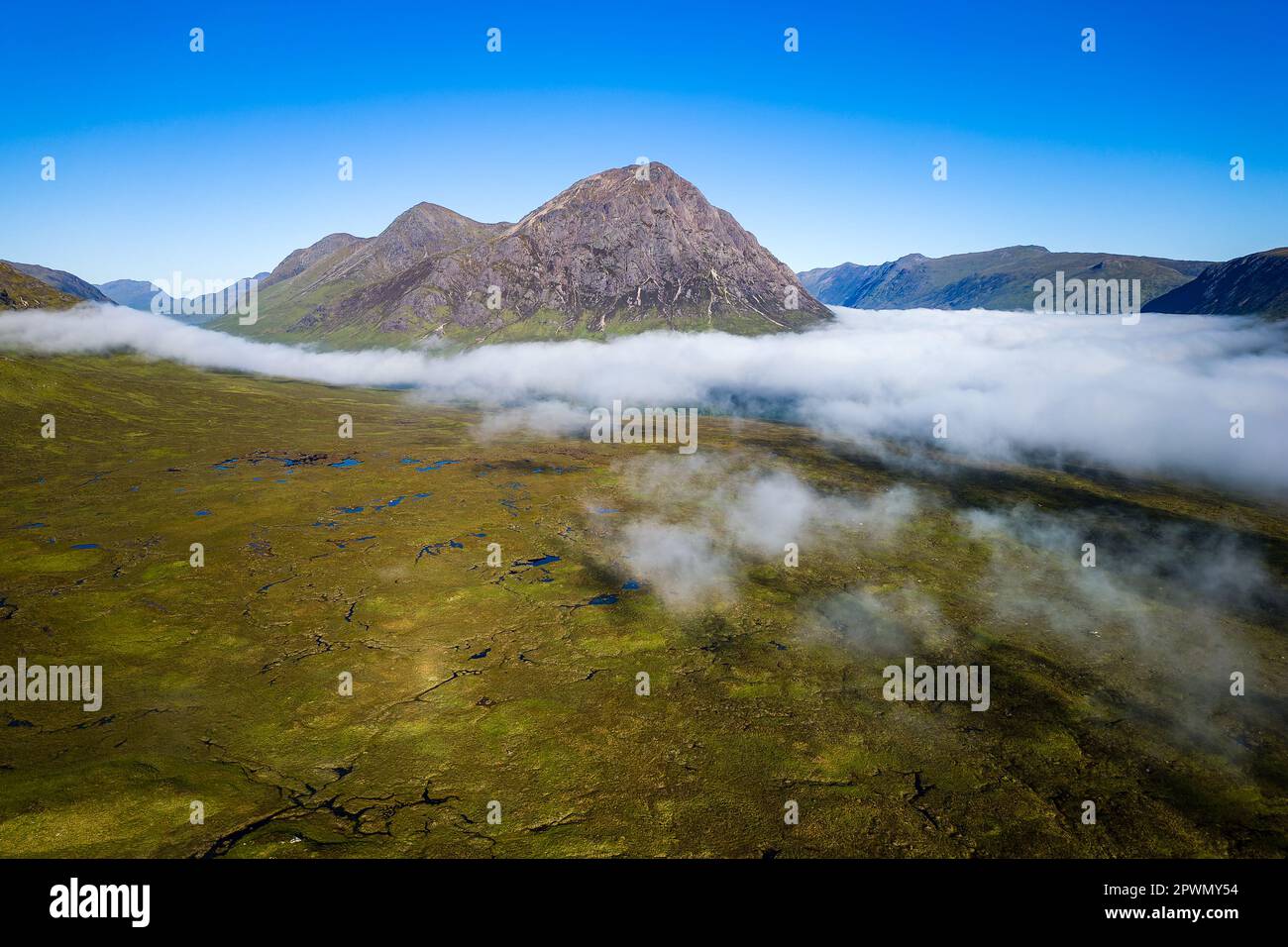 Aerial view of mountain peaks rising above low lying fog in a deserted ...