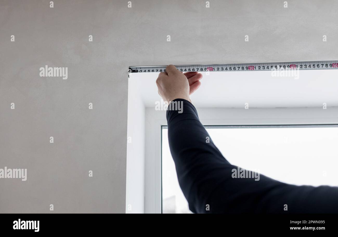 repairman holding tape measure. professional worker using tape measure ...