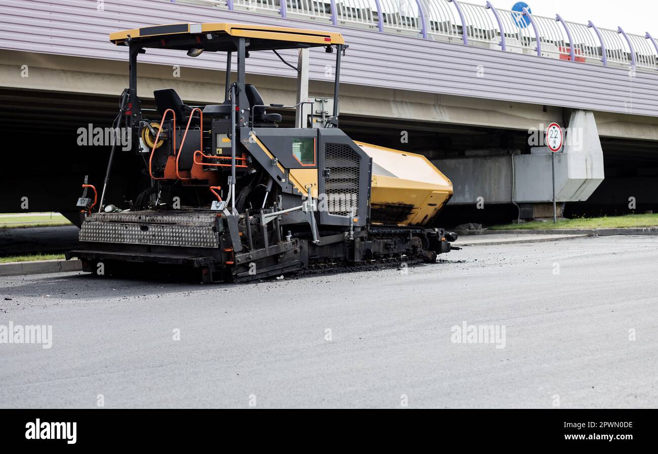 asphalt spreader machine with yellow color on the new road construction ...