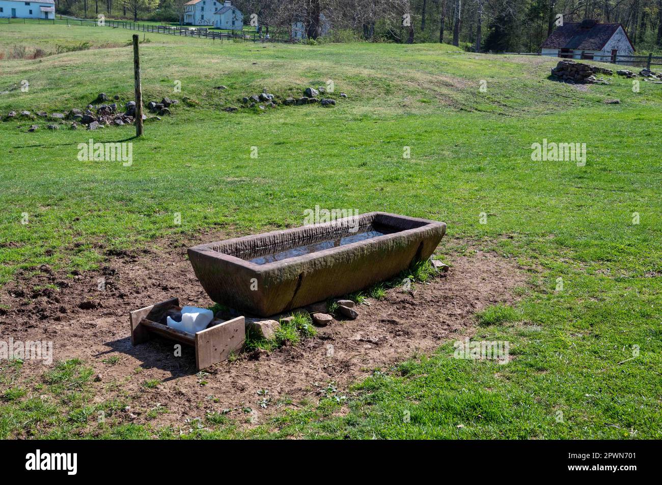 Rustic long stone farm animal water trough salt lick in village scene ...