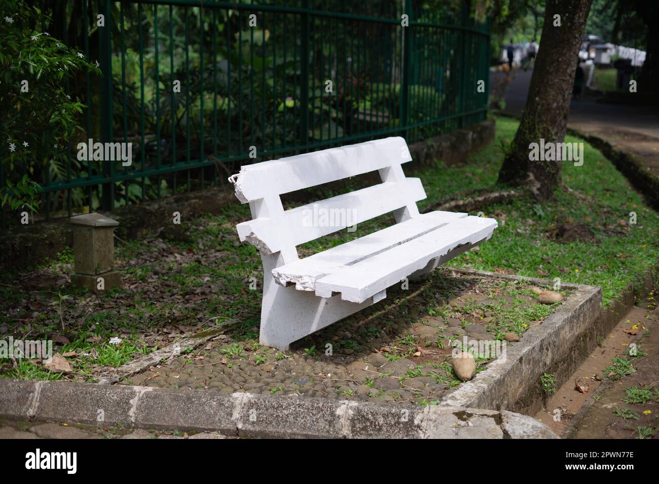garden bench made of cement and painted white under a big tree Stock ...
