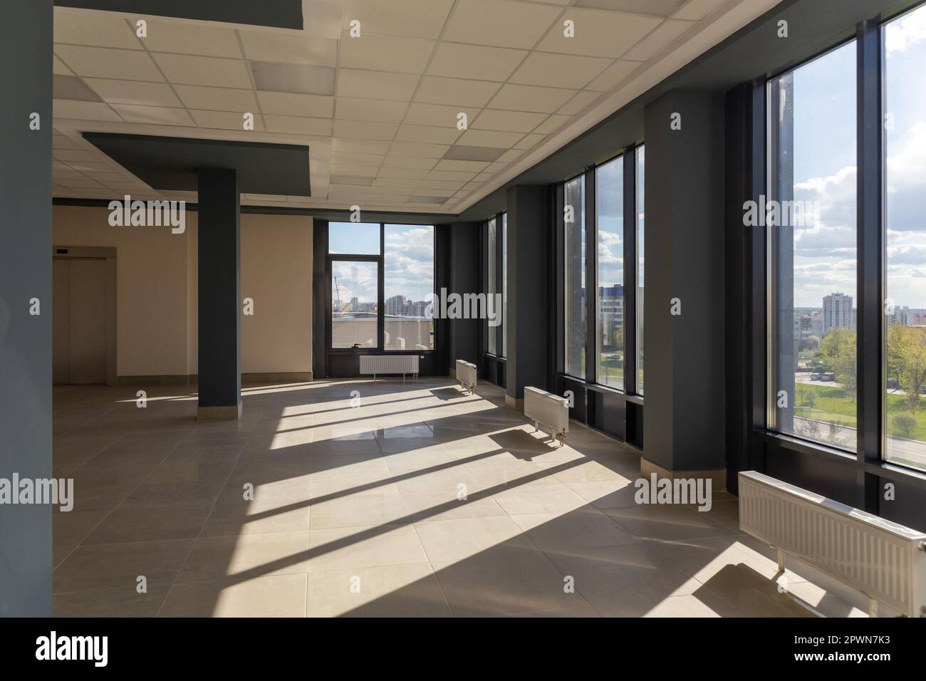 A large, spacious, empty room with huge windows and floor-mounted ...