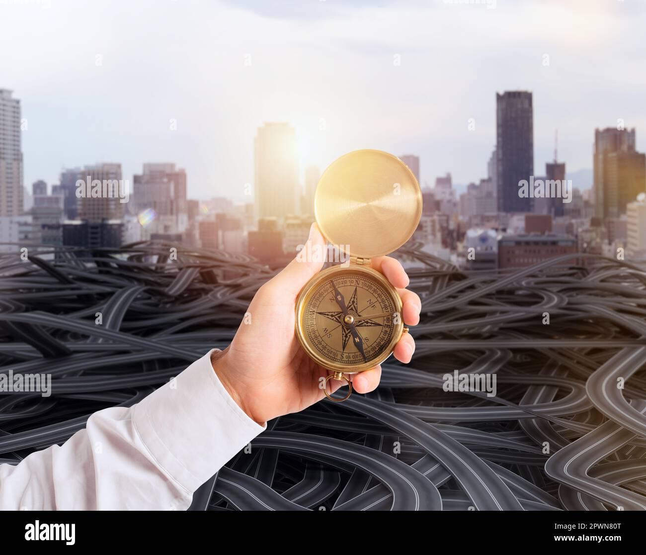 Businessman holds a compass to help himself to find the correct way ...