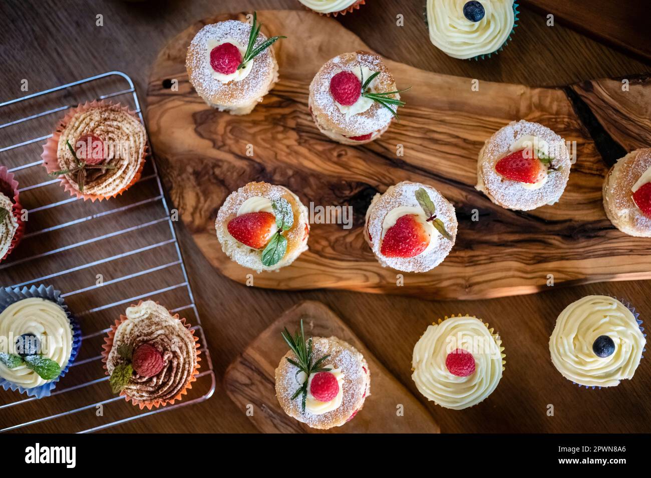 Beautiful mini Victoria sponges and cupcakes on seasoned wooden ...