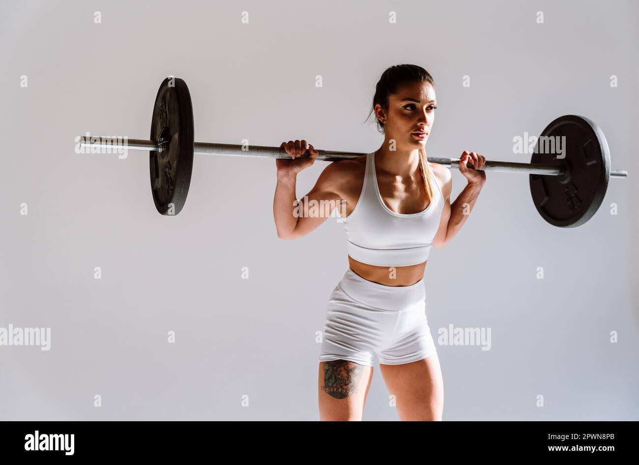 Young female athlete training in a gym using sport equipment. Fit woman ...