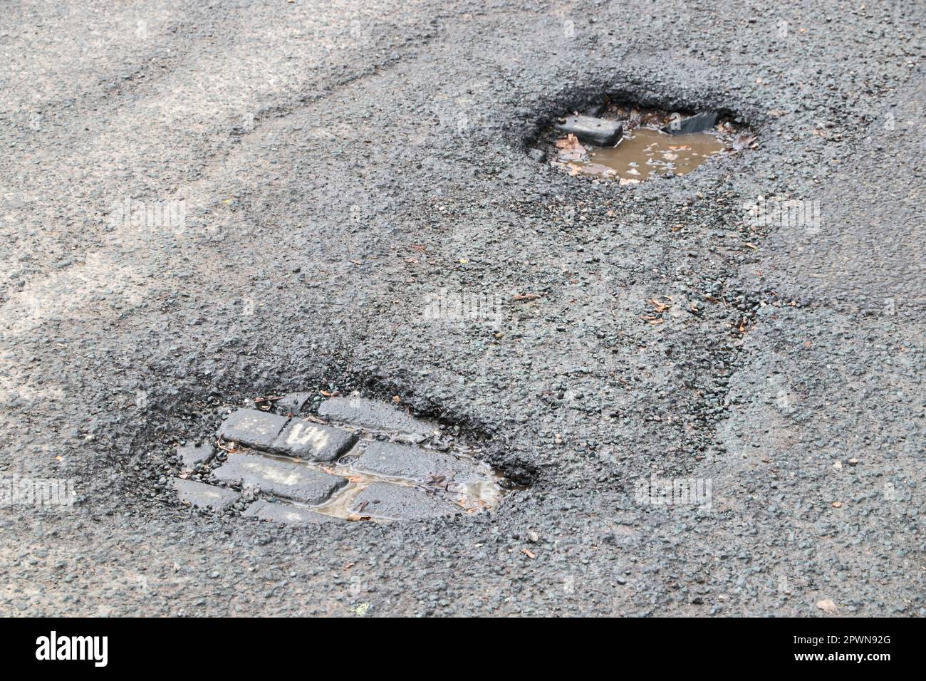 Potholes in road surface Stock Photo - Alamy