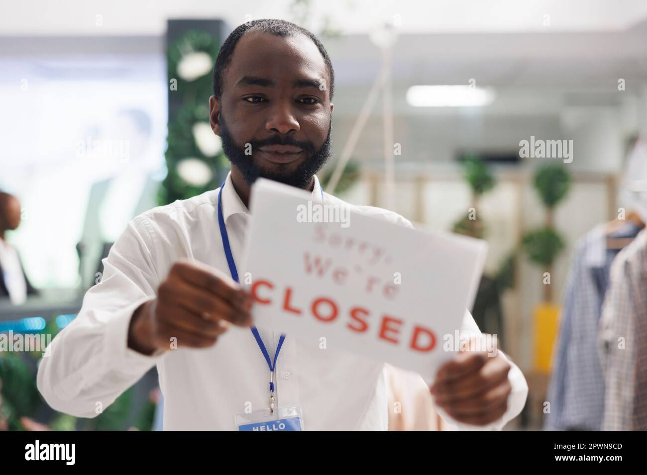 Fashion garment department store african american employee hanging ...