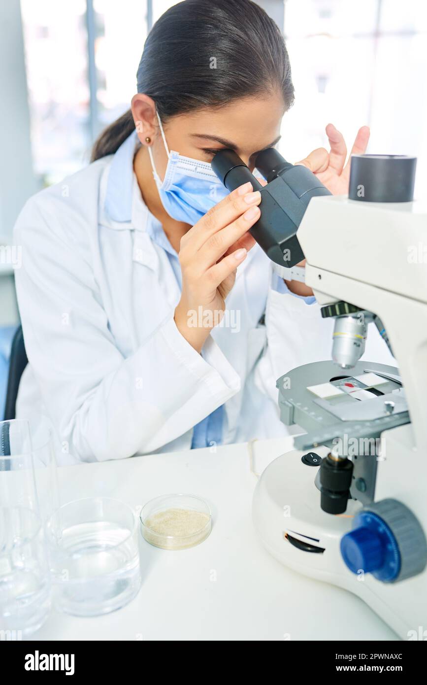 Advancing through the sciences. a young scientist using a microscope in ...
