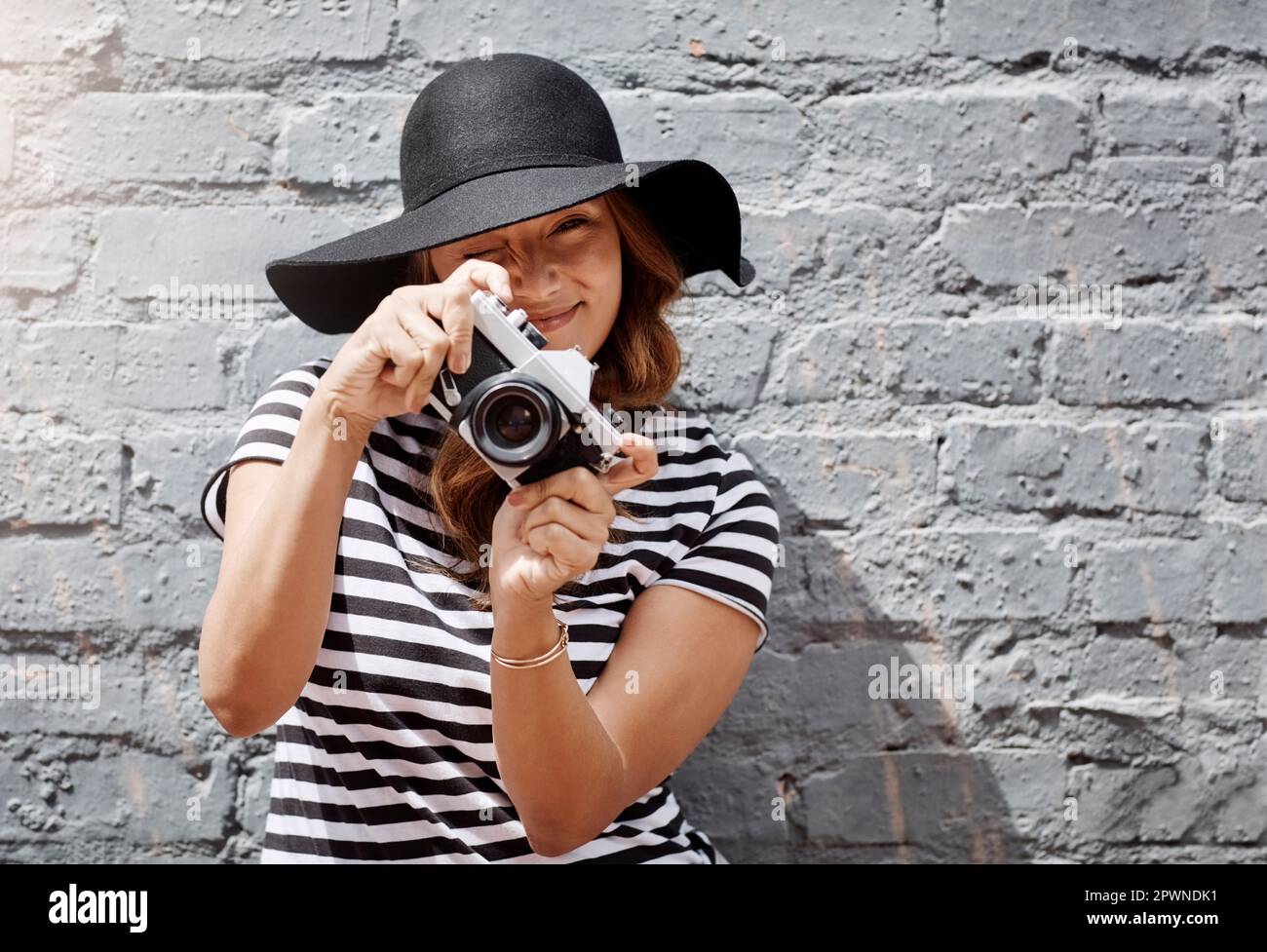 Pose for the camera. a young woman taking a picture with her camera ...