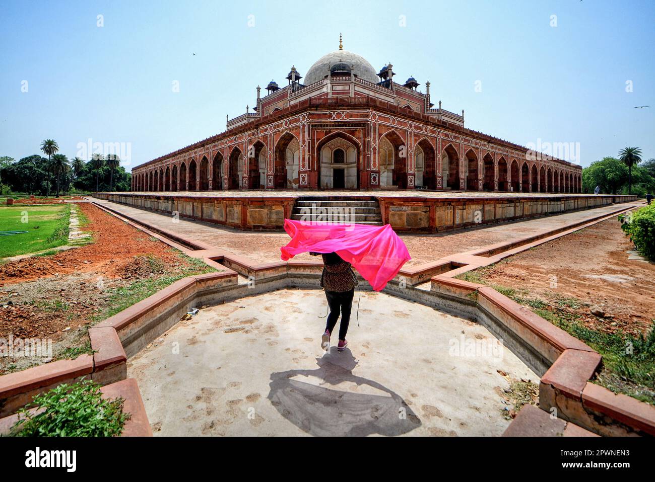A woman with a colorful scarf walks inside the courtyard of Humayun ...