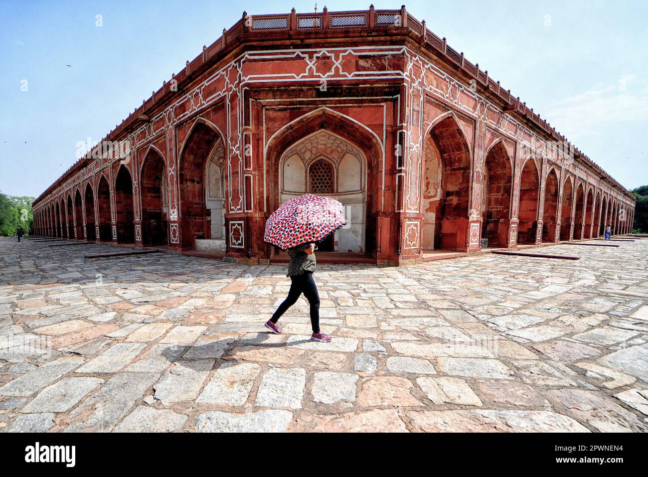 A visitor holding an umbrella walks inside the courtyard of Humayun ...