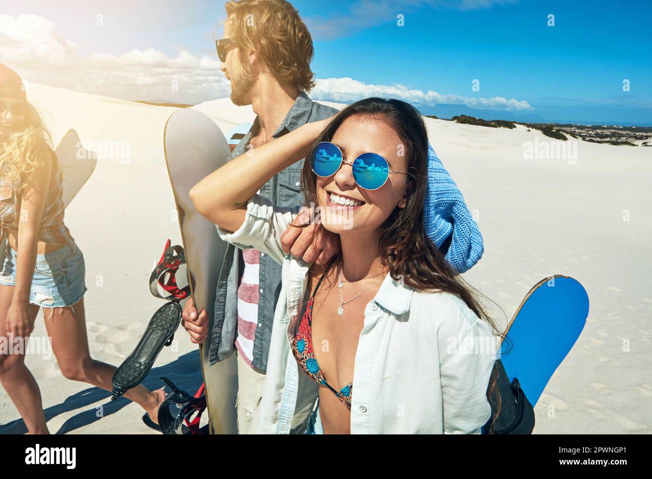 Sand boarding fun in the sun. a group of young friends sandboarding in ...