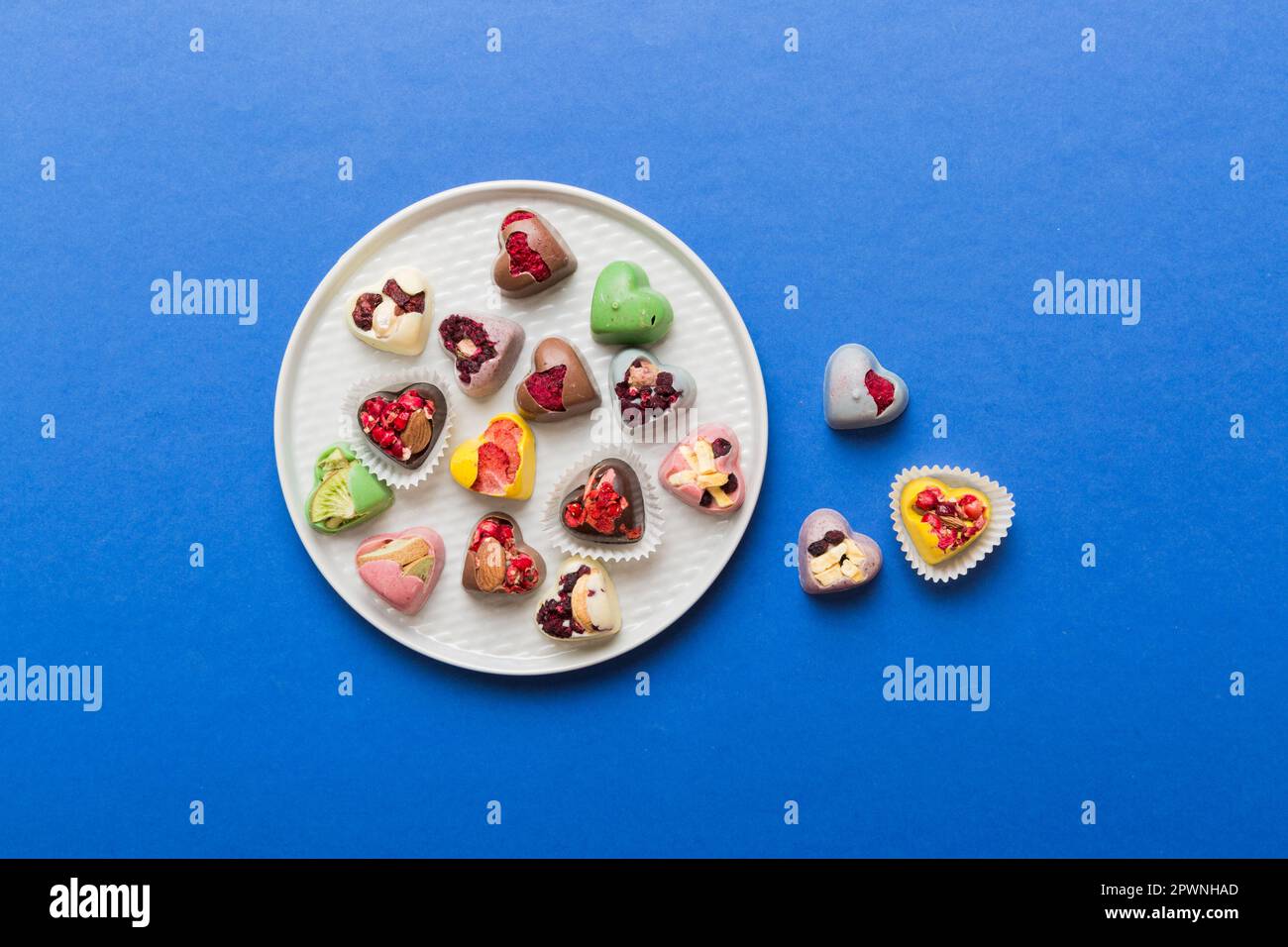 Plate with different chocolate on colored background. Assortment of ...