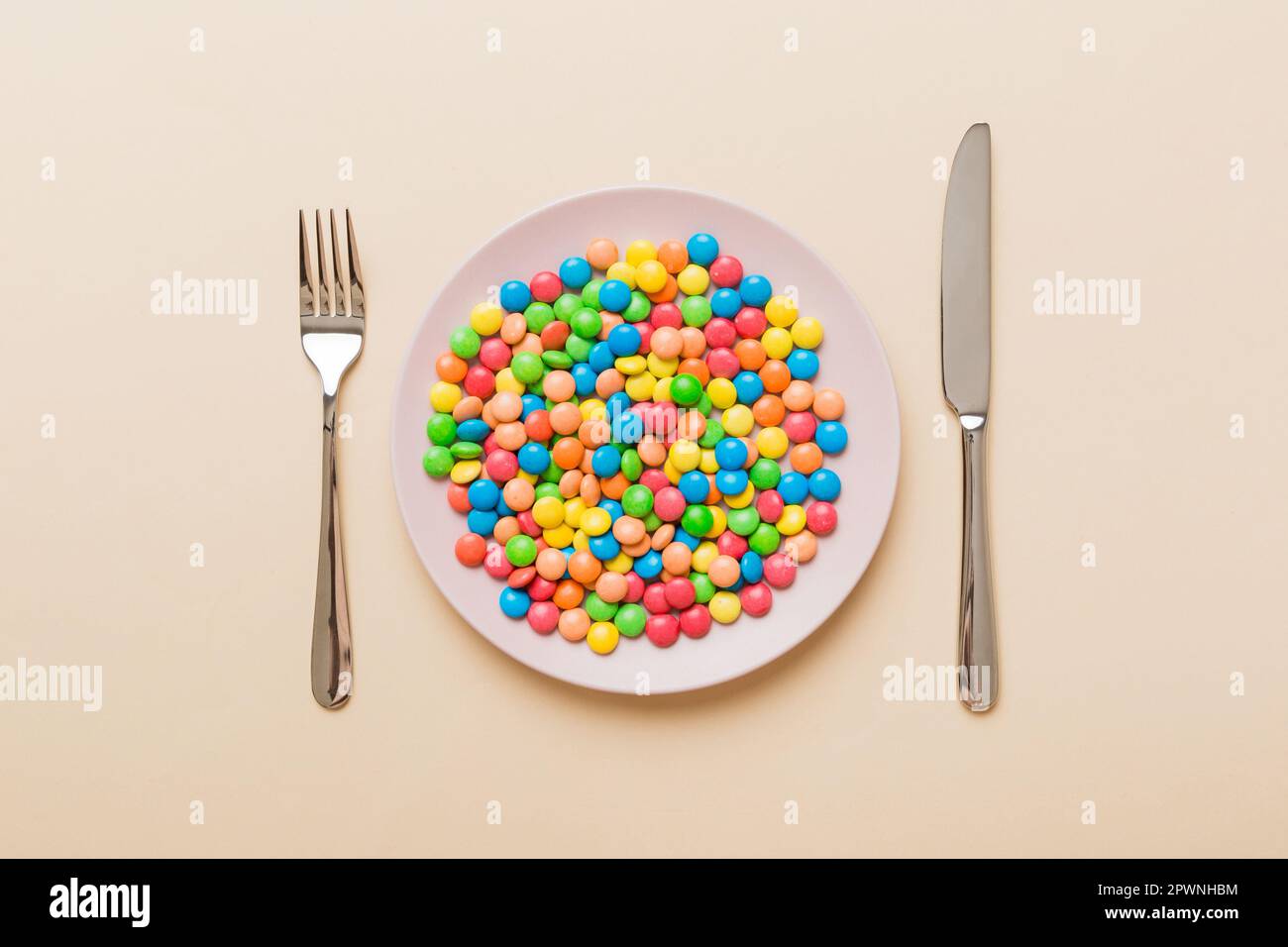 cutlery on table and sweet plate of candy. Health and obesity concept ...