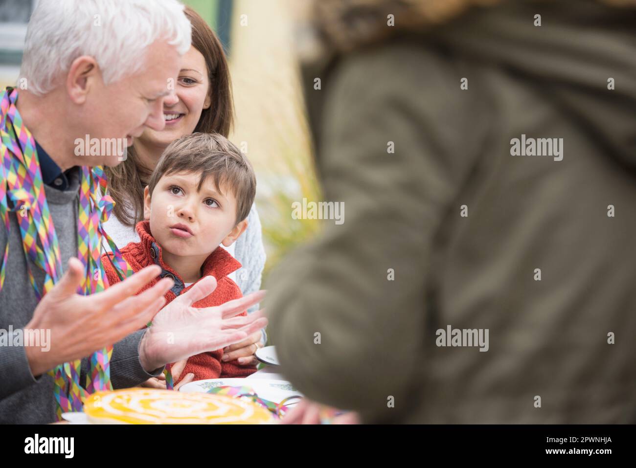 Boy keenly listening to his grandfather on his birthday, Bavaria ...