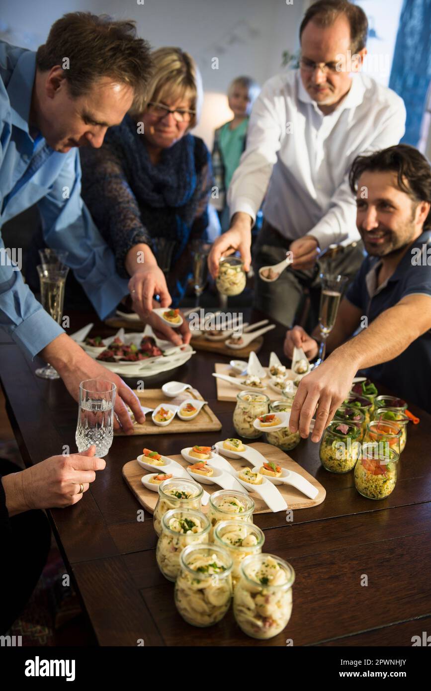 Party guests helping themself with the buffet Stock Photo - Alamy