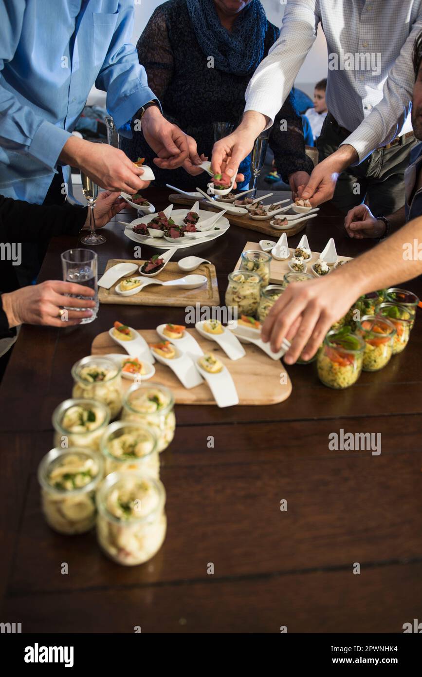 Party guests helping themself with the buffet Stock Photo - Alamy
