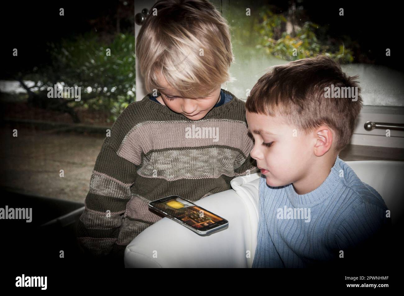Two boys using smart phone at home Stock Photo - Alamy