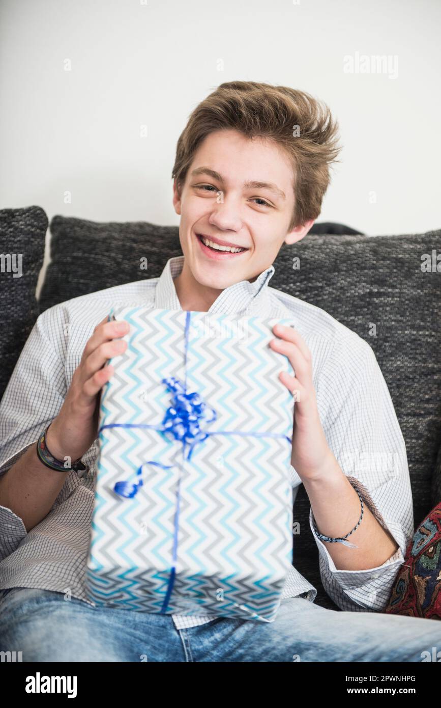 Portrait of teenage boy with Christmas present Stock Photo - Alamy