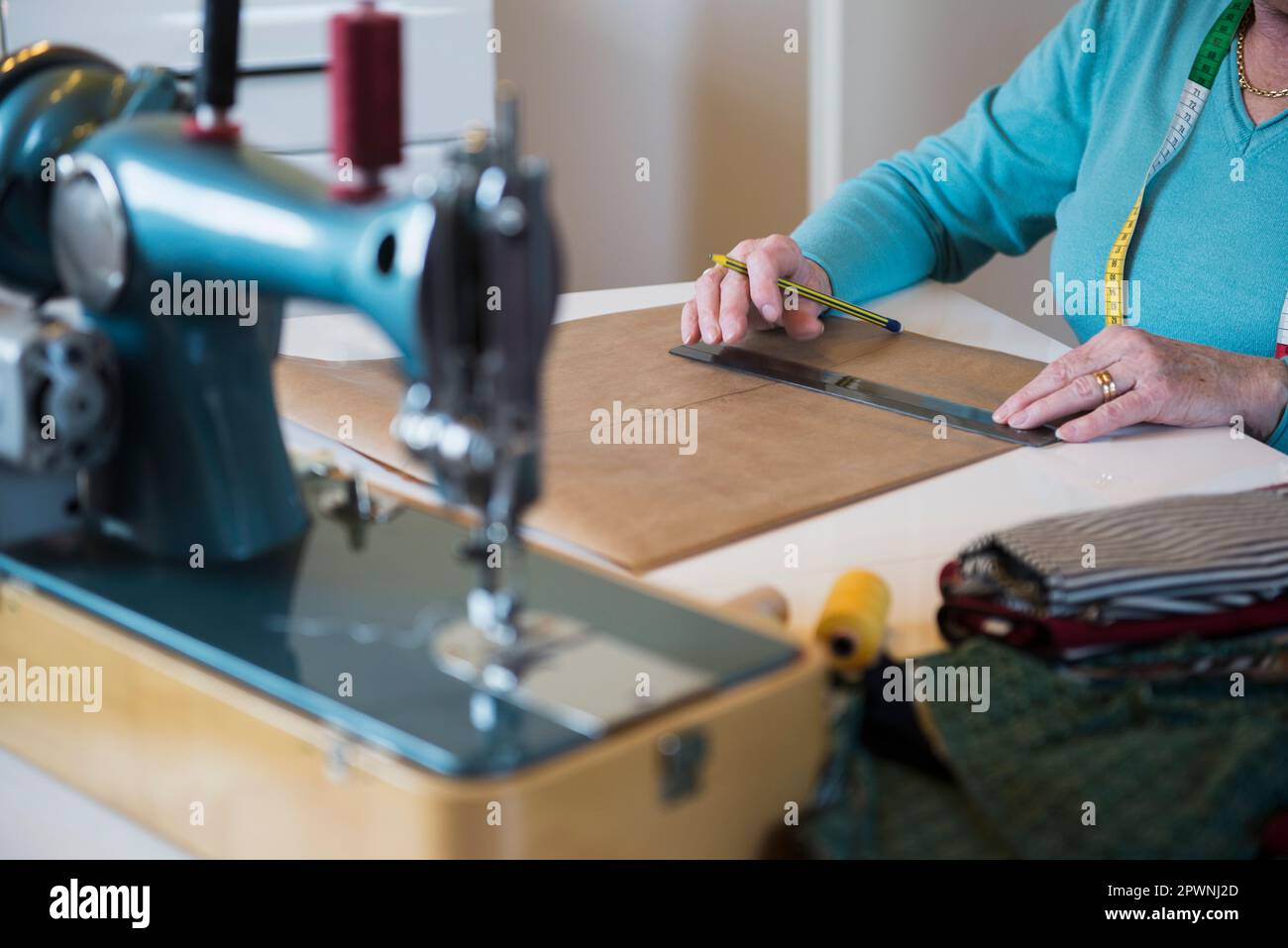 Old woman measuring with a ruler on sewing desk Stock Photo - Alamy