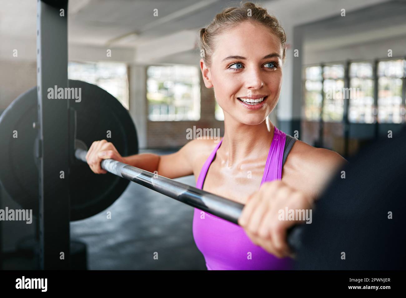 Me myself and iron. a young woman working out with weights at the gym ...