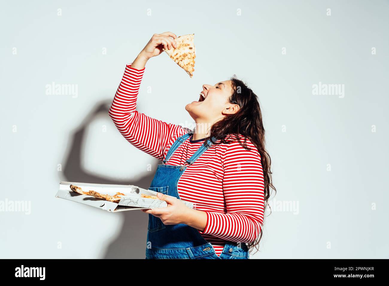 Plus size woman model posing in studio and having fun. Eating italian ...