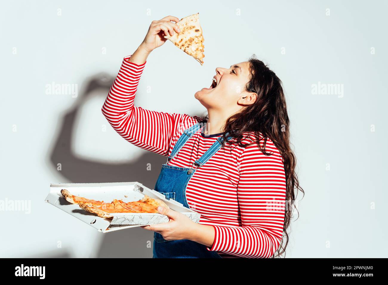 Plus size woman model posing in studio and having fun. Eating italian ...
